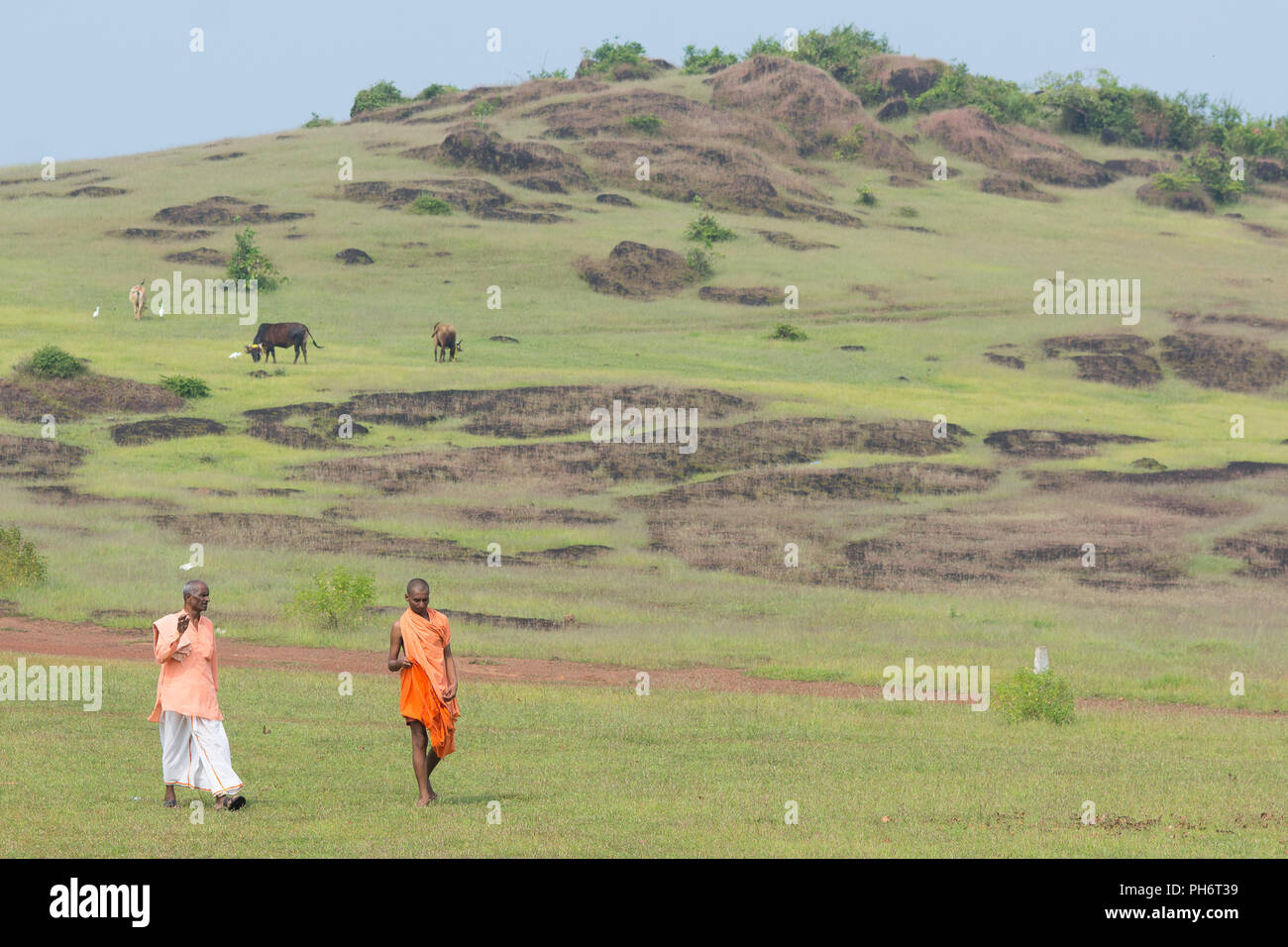 Goa, India - July 8, 2018 - Two hinduist priests walking through hills ...