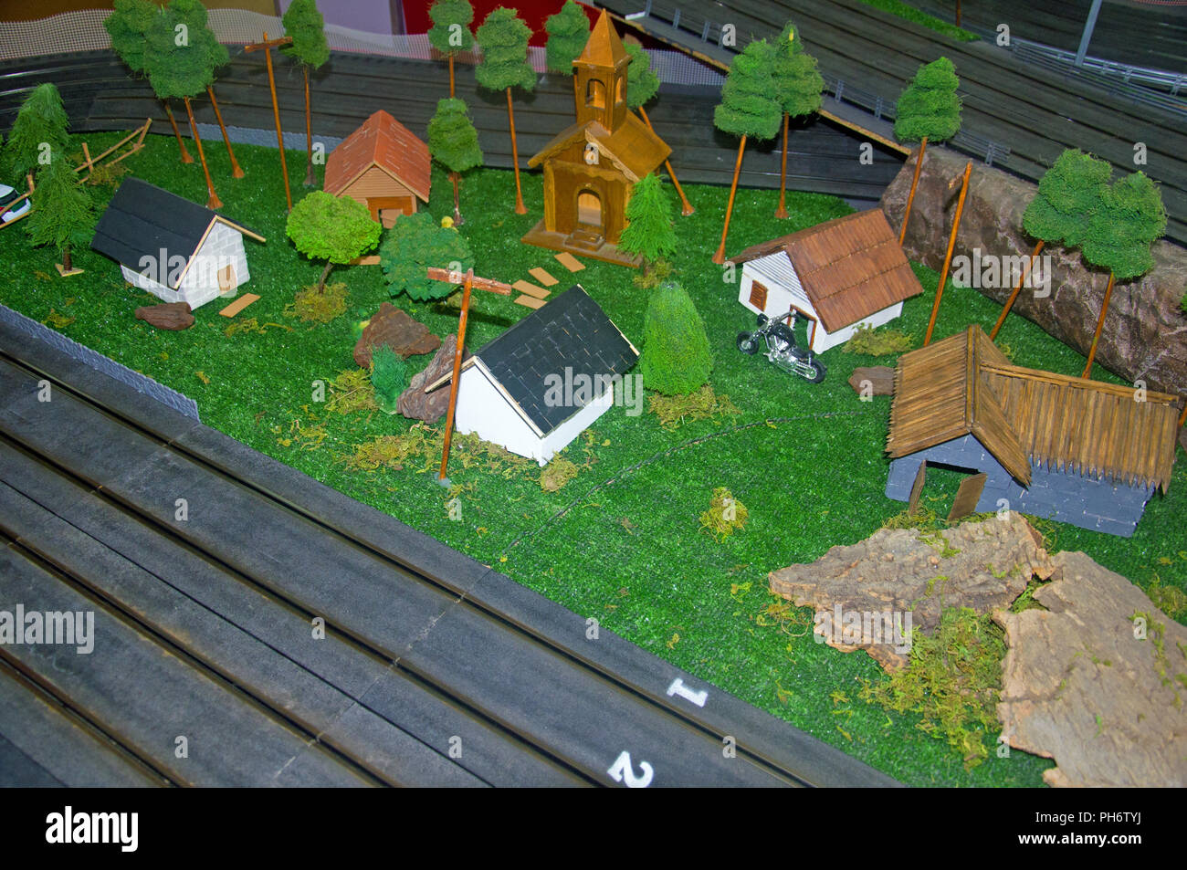 Small toy church, different houses and trees around, right up view ...