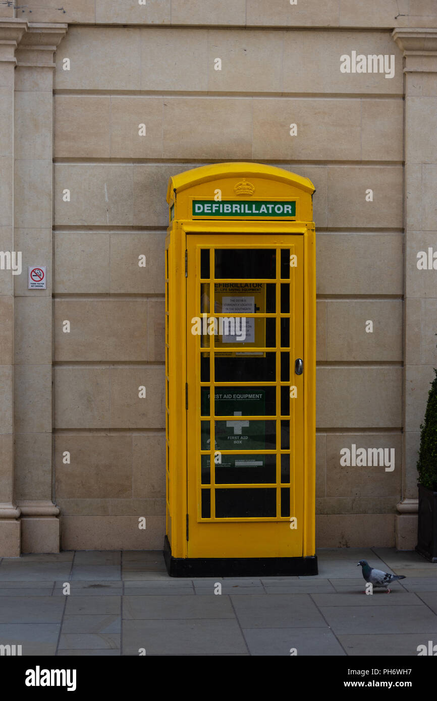 Traditional telephone box painted yellow and used for a defibrillator ...