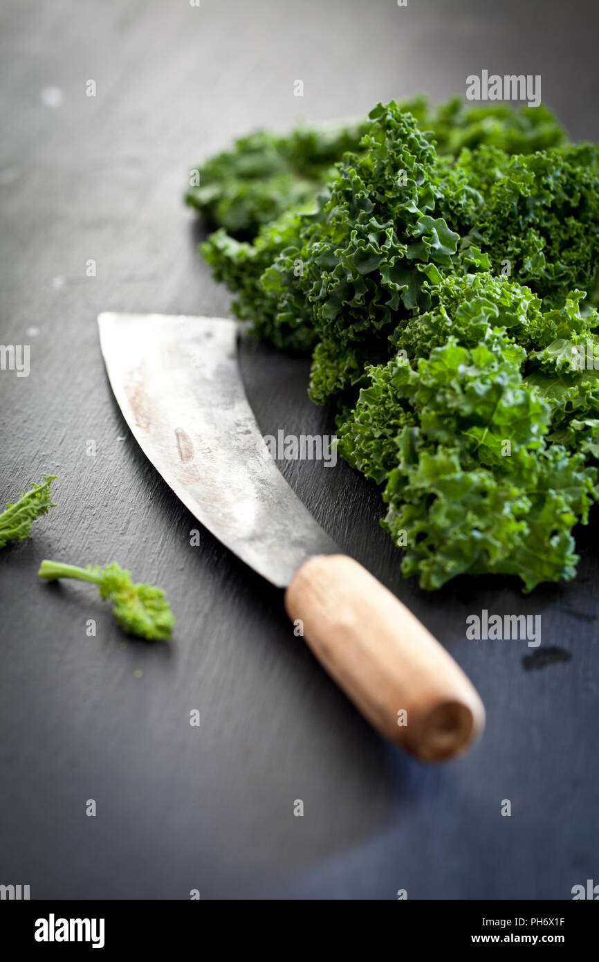 Fresh kale being chopped with large chef's knife Stock Photo - Alamy