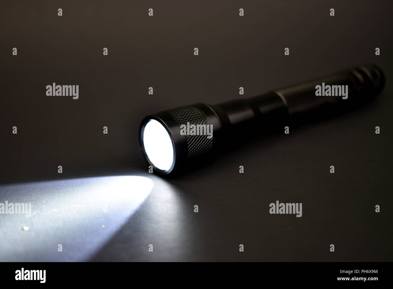 Turned on black flashlight with a black background. The black ...