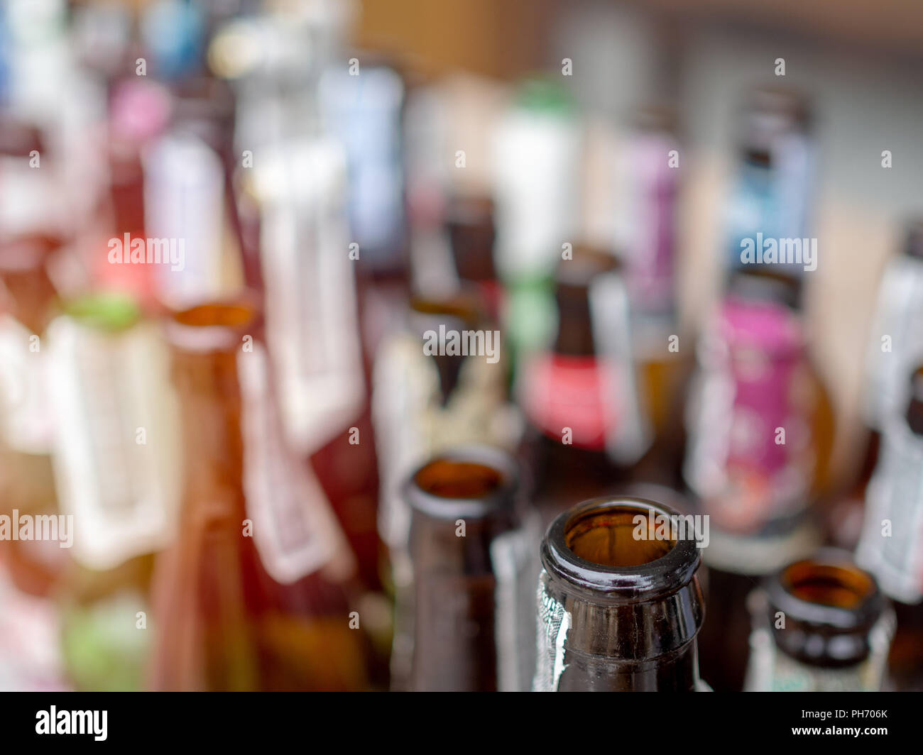 Close-up various types of empty bottled beer on wooden counter bar ...