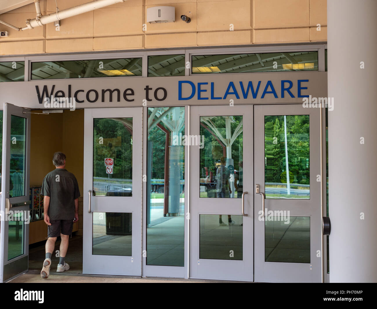 Welcome to Delaware sign above a rest area stop, man walking in Stock ...