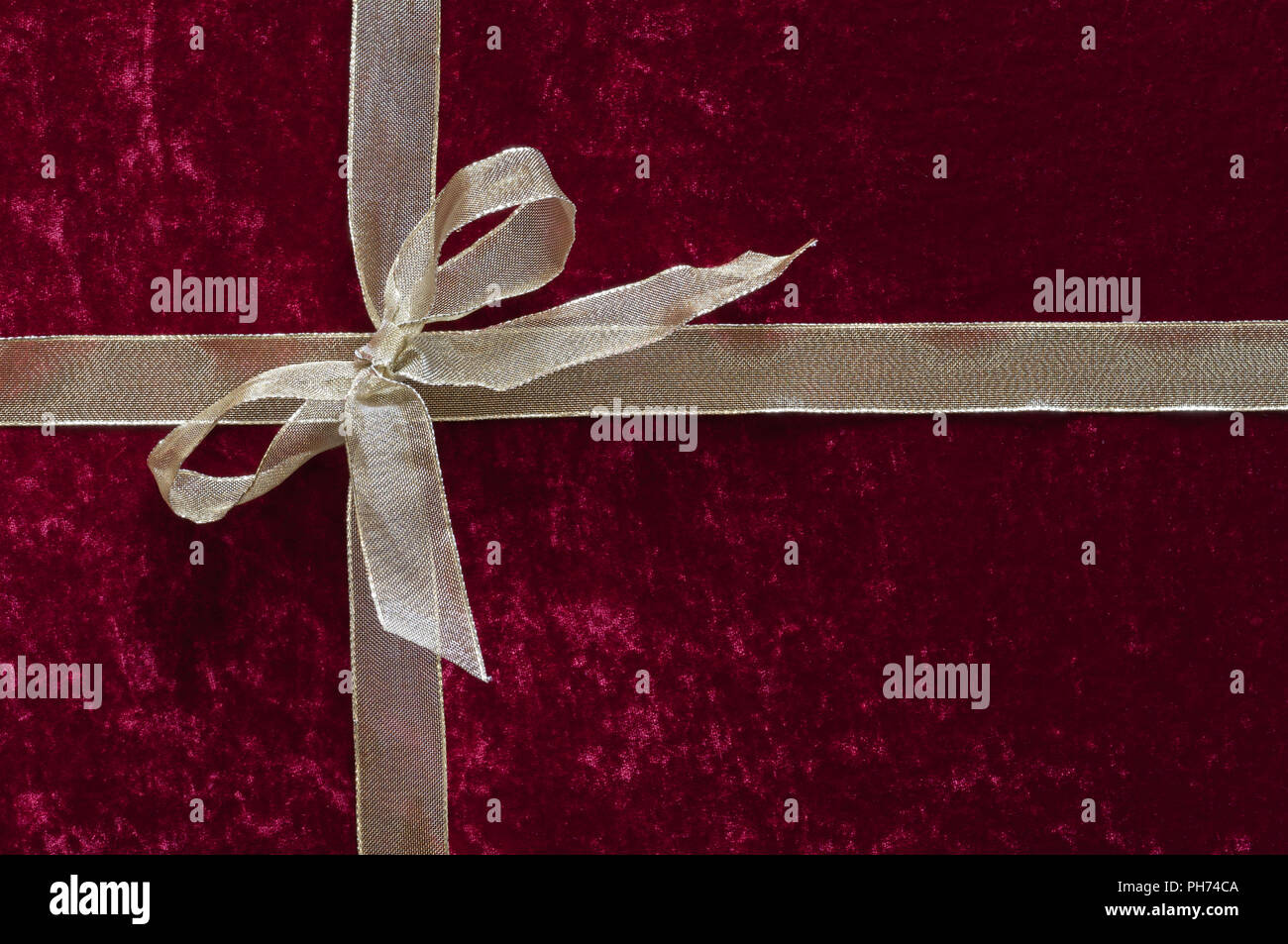 Red velvet with golden bow Stock Photo - Alamy