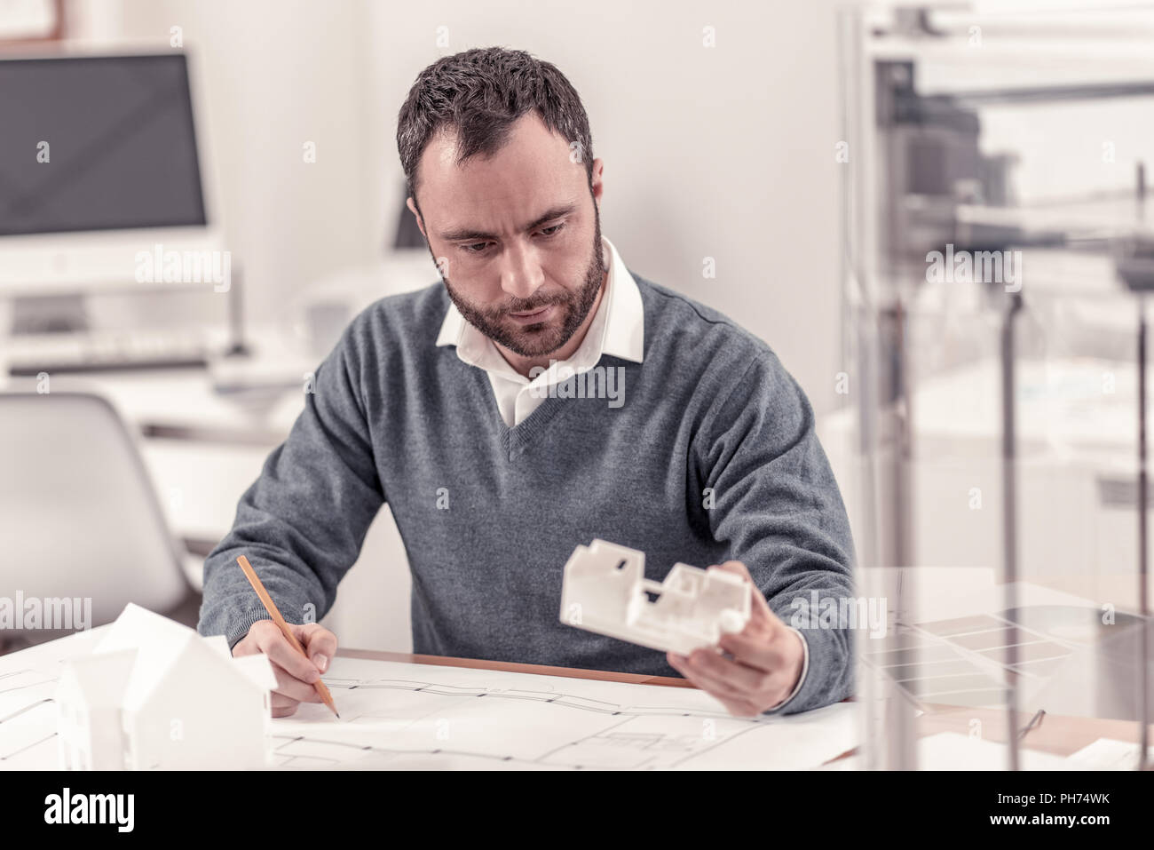 Hardworking engineer comparing his drawings with layout Stock Photo - Alamy