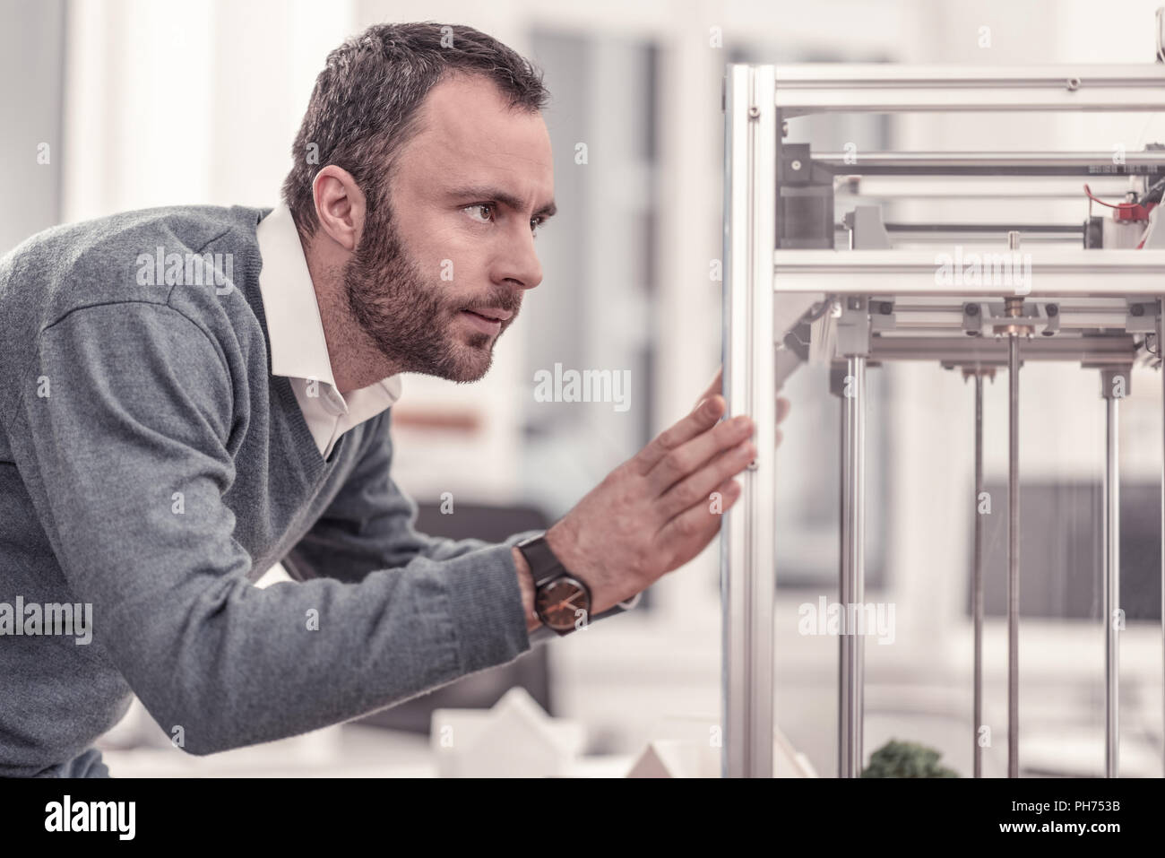 Bearded concentrated adult man watching at 3D printer Stock Photo - Alamy