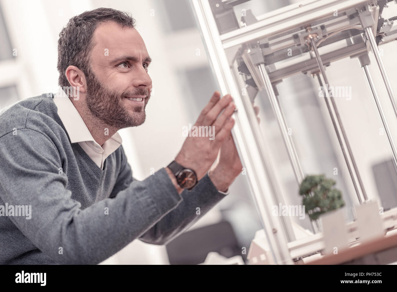 Smiling adult positive man touching 3D printer Stock Photo - Alamy