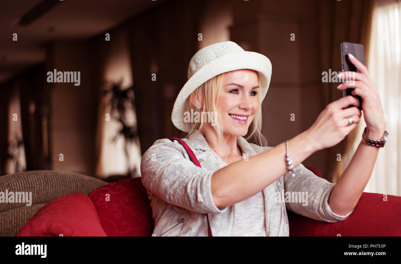 Smiling woman taking mobile selfie hi-res stock photography and images ...