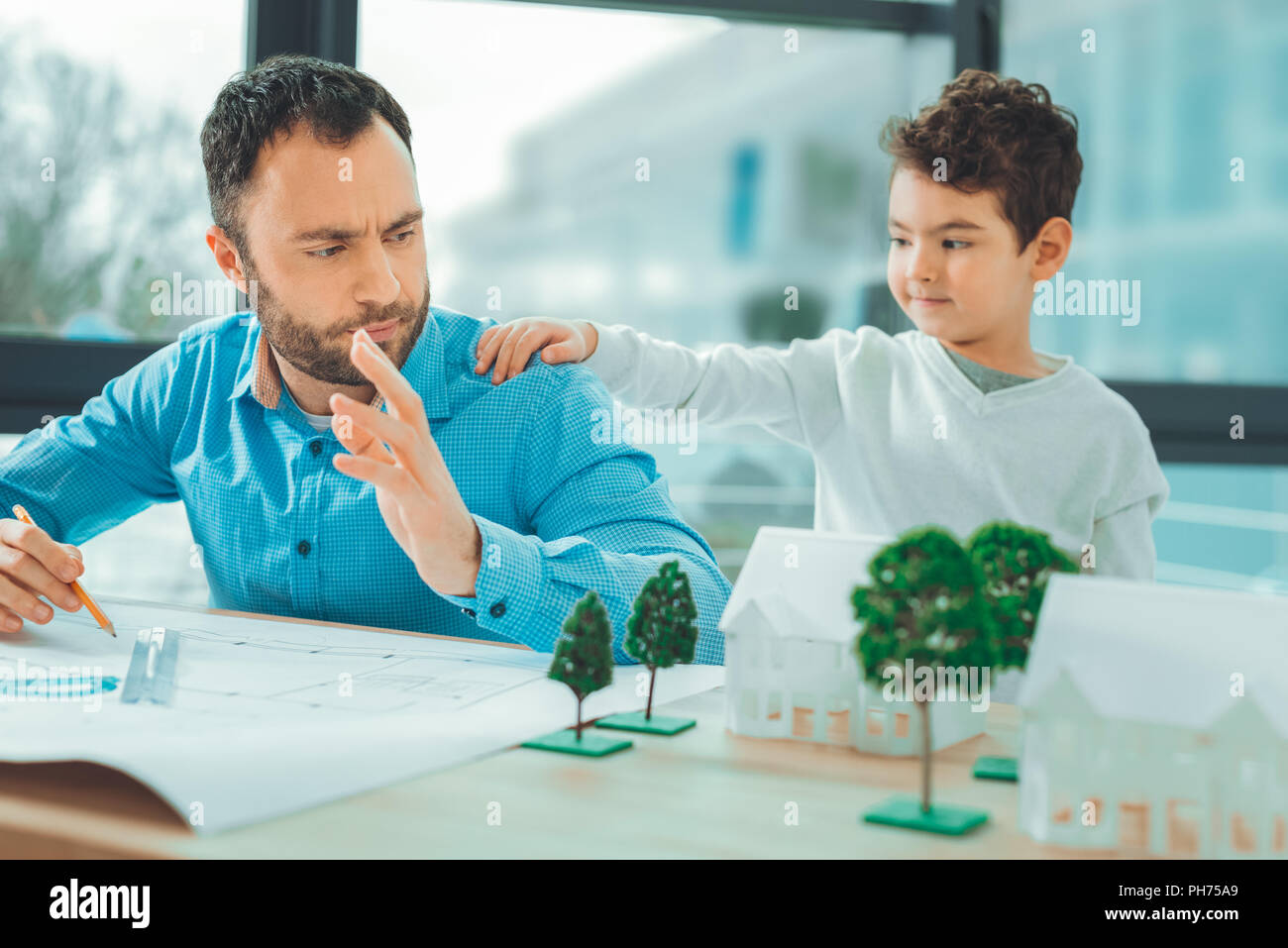 Negative delighted architect being angry with son Stock Photo - Alamy