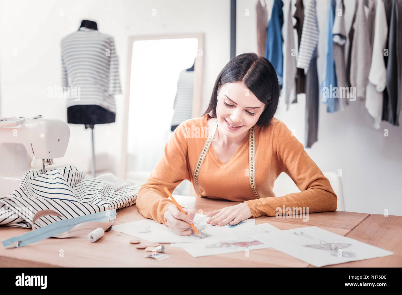 Talented dressmaker drawing bright clothes sketches Stock Photo - Alamy