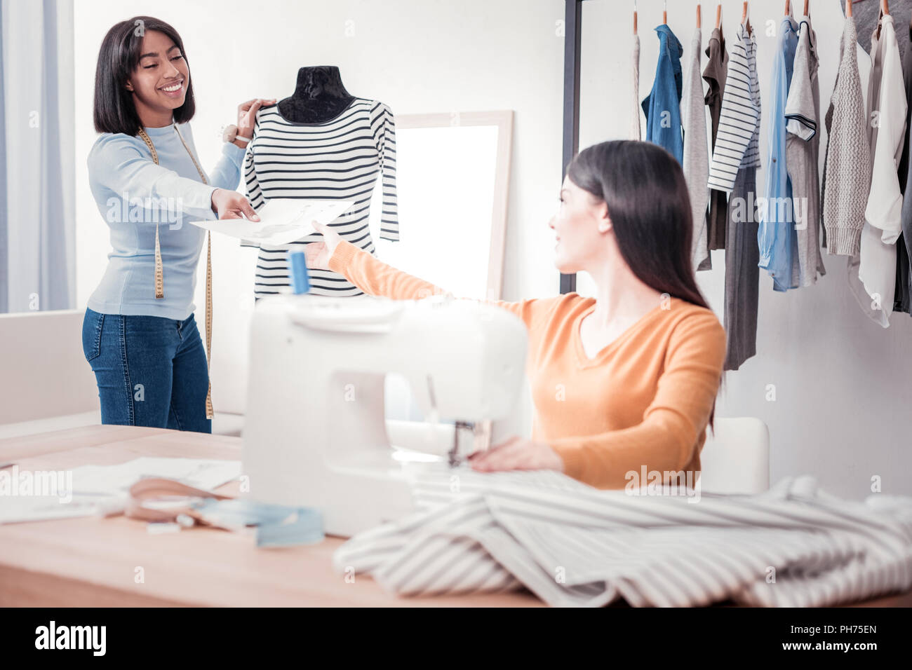 Enthusiastic tailors working on new clothes collection Stock Photo - Alamy