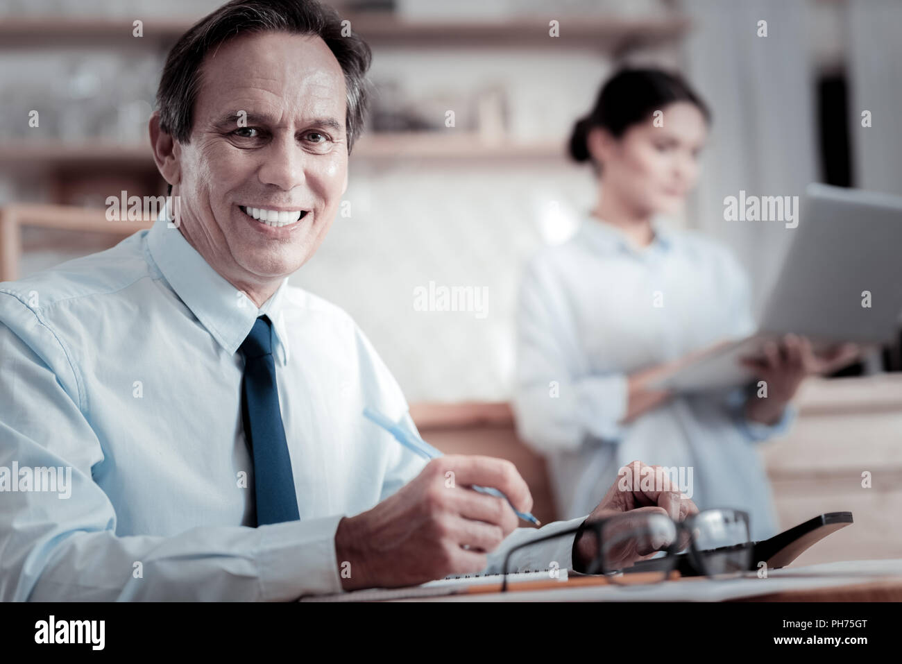 Cheerful businessman smiling while working Stock Photo - Alamy