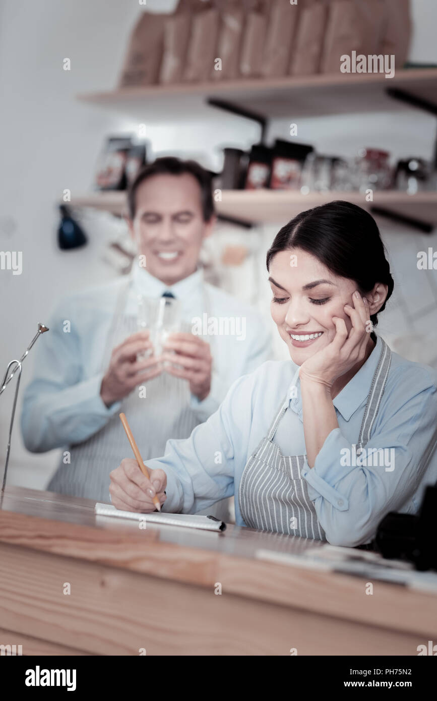 Relaxed waitress making notes and a waiter holding a glass Stock Photo ...