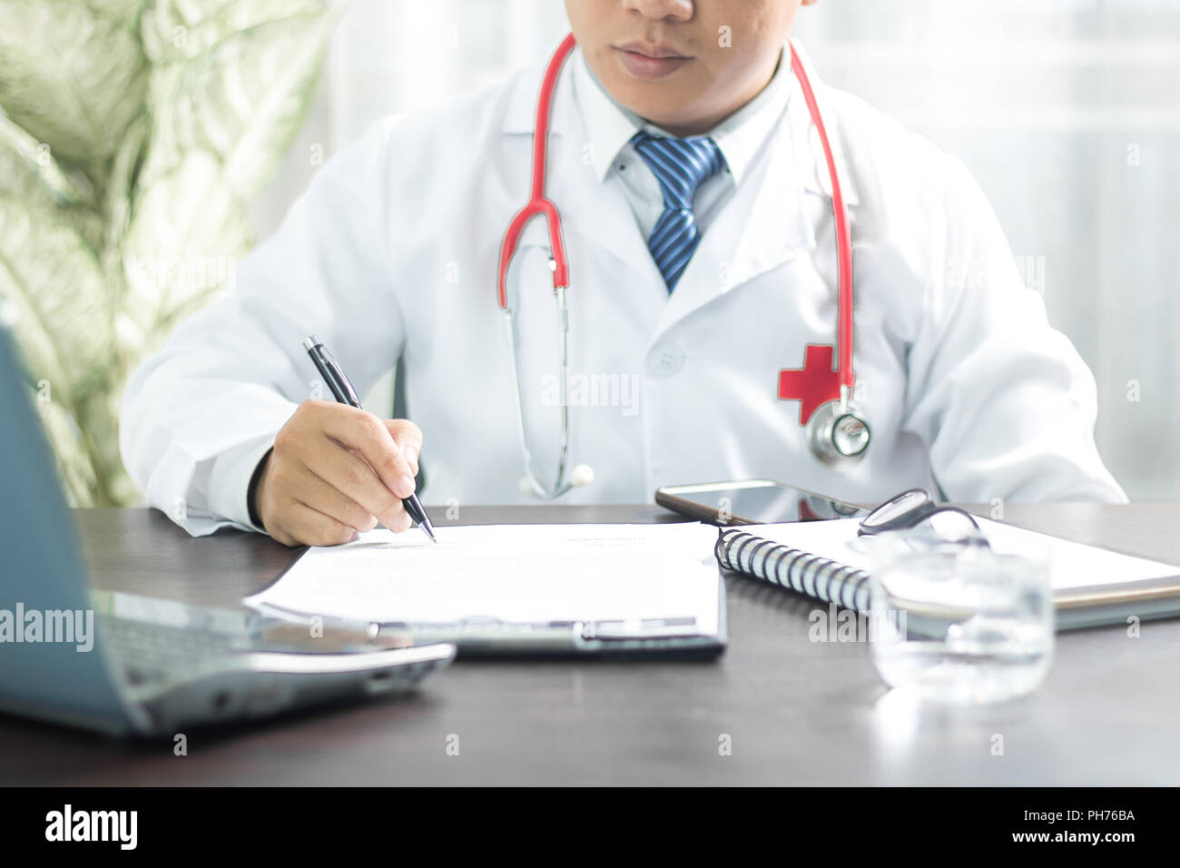 doctor writing information to patient on medicine paper in clinic for ...