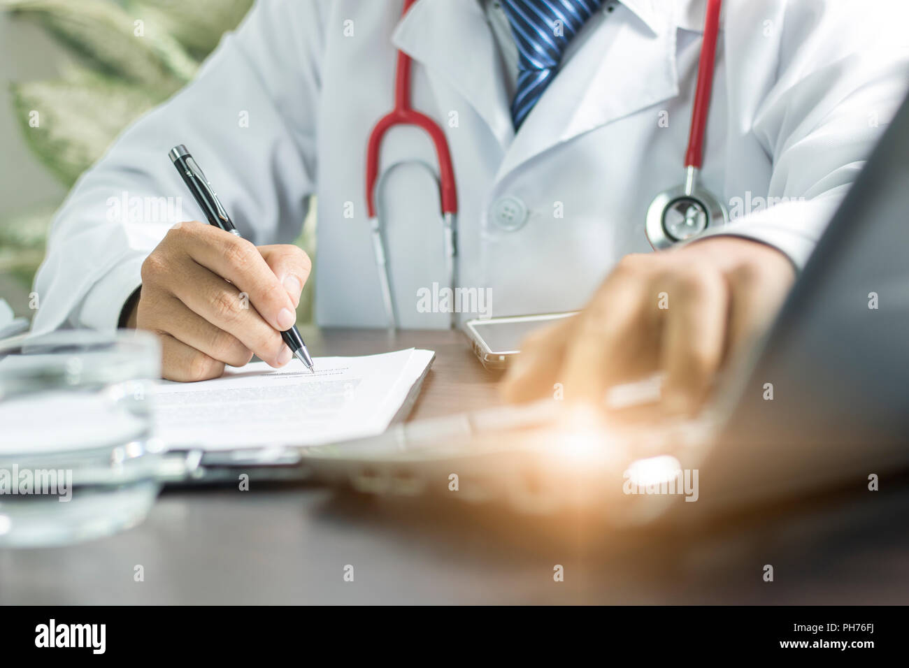 doctor writing information to patient on medicine paper in clinic for ...
