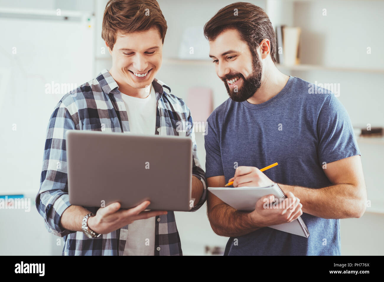 Positive young men working together Stock Photo - Alamy