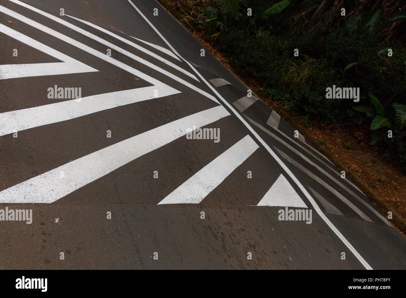 A side view of a speed bump one side newly painted and the other to ...