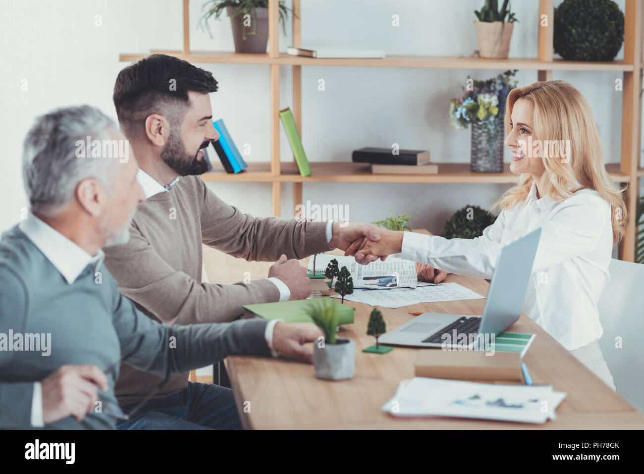 Optimistic three colleagues becoming partners Stock Photo - Alamy