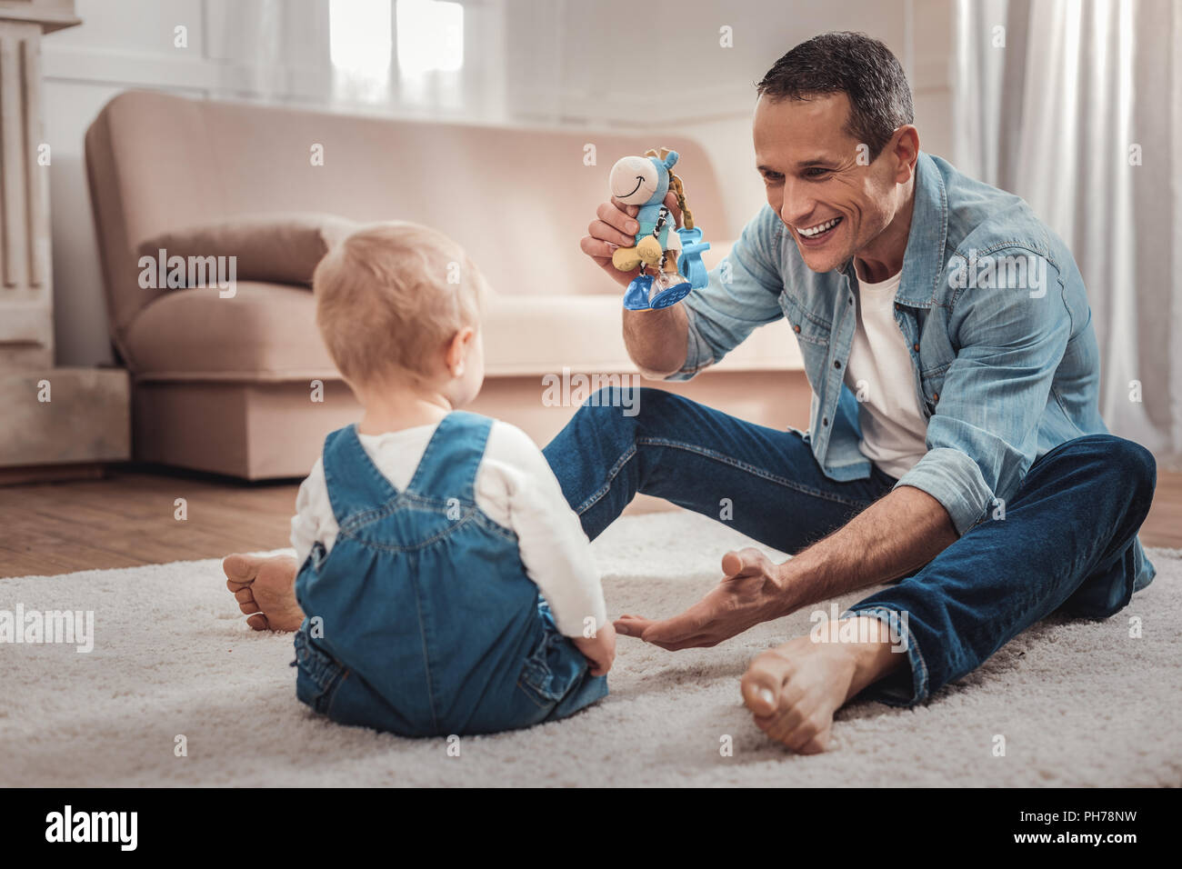 Delighted nice man playing with his baby Stock Photo - Alamy