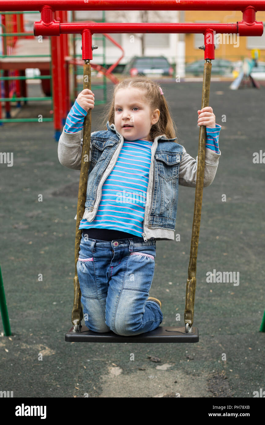 Girl swinging in a playground Stock Photo - Alamy