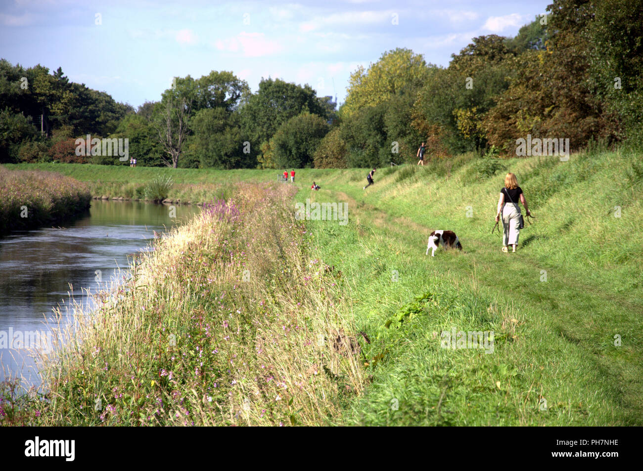 People enjoy the last of the Summer's sunshine beside the river Mersey ...