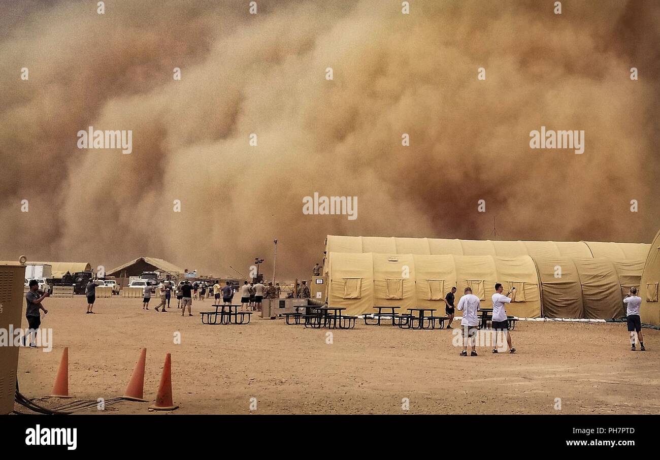 U.S. service members observe and take photos of a sand storm at ...