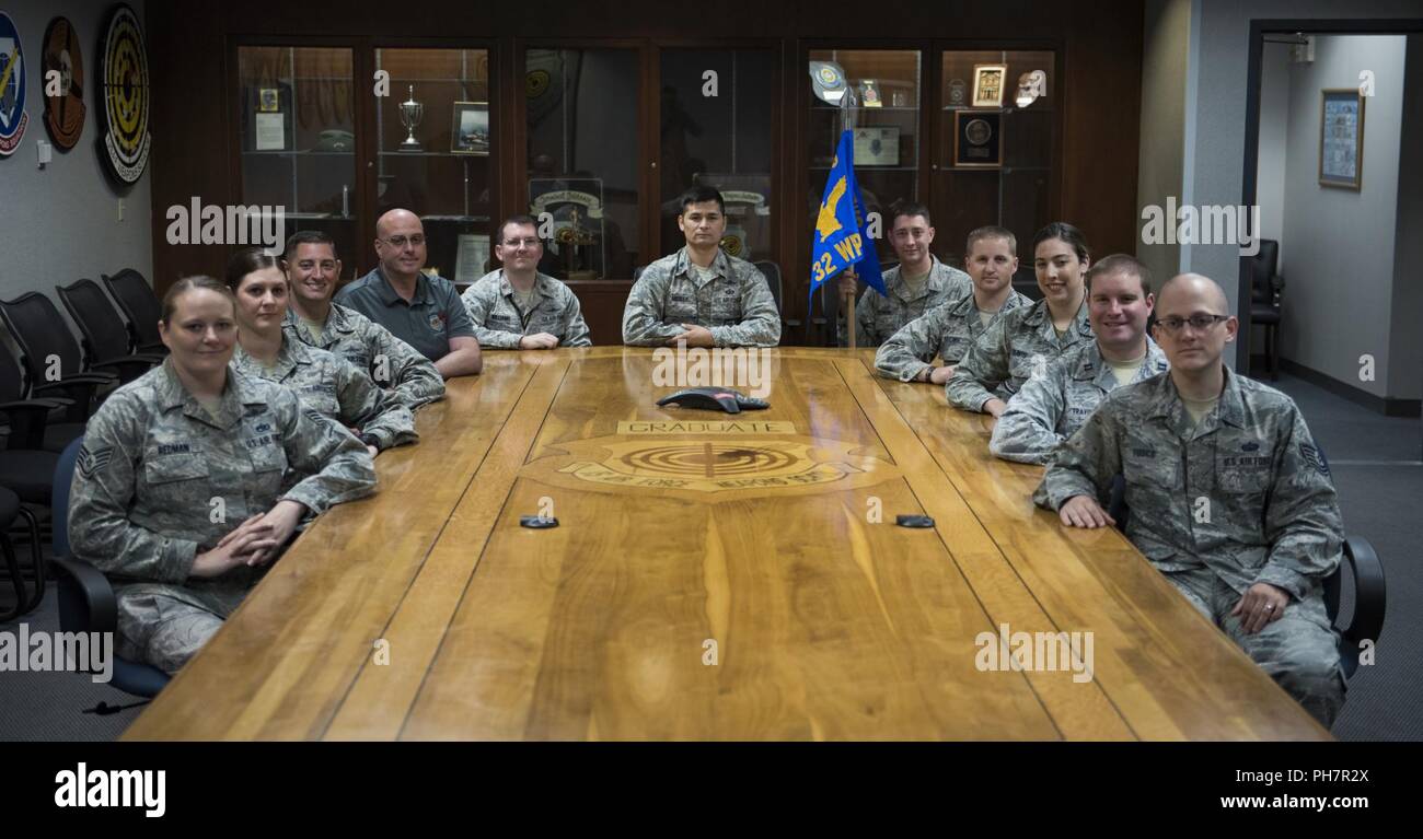 Members assigned to the 32nd Weapons Squadron gather around a table ...