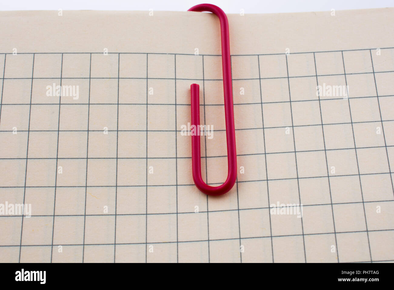 Colored paper clip on a checked notebook page Stock Photo - Alamy