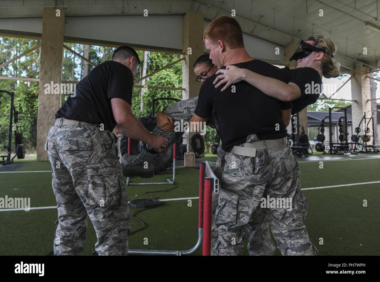 Junior ROTC cadets assist a blindfolded cadet through an obstacle ...