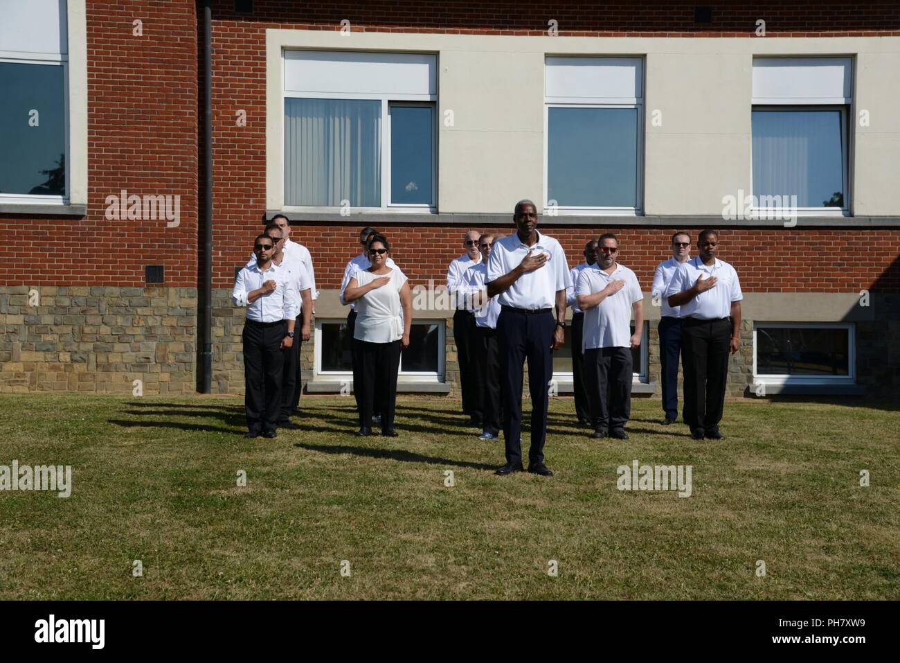 U.S. Army Garrison Benelux civilian employees stand at attention and ...