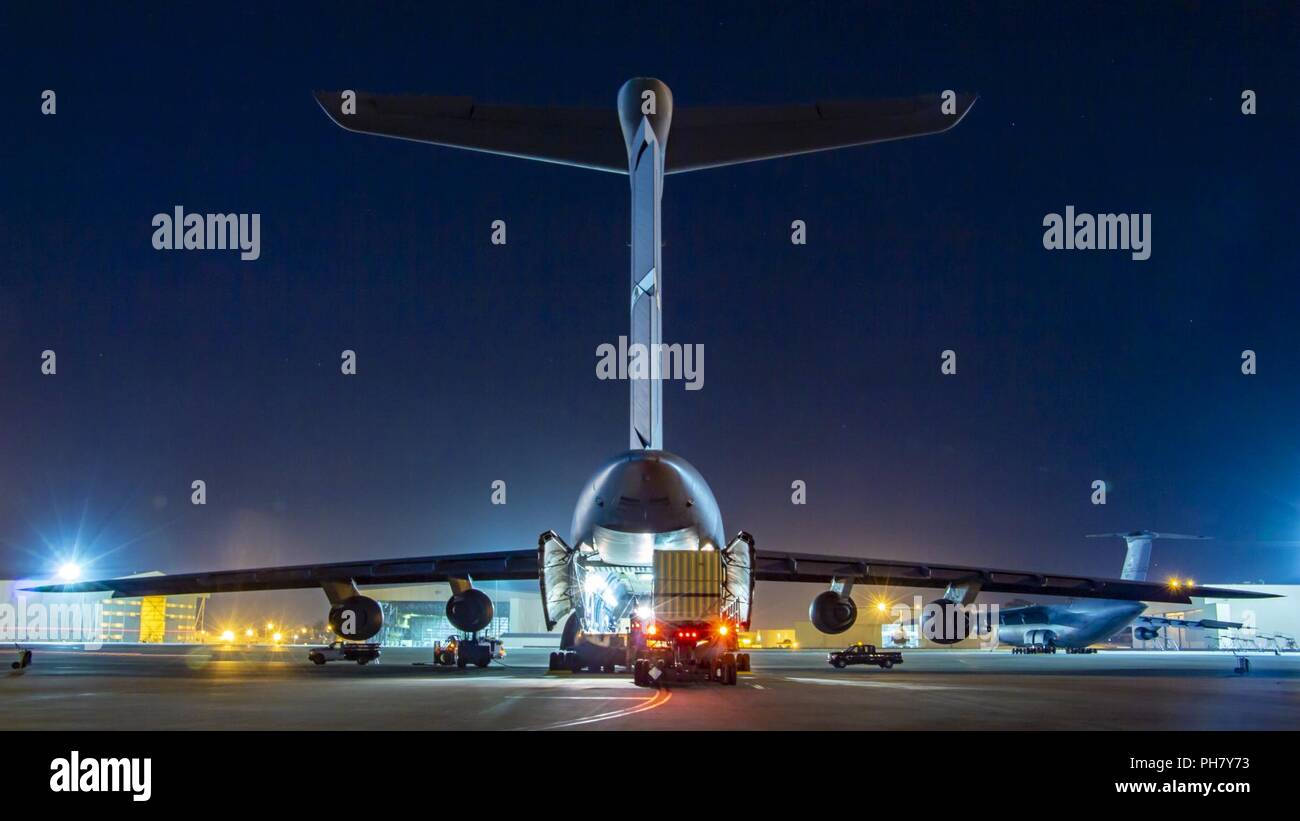 U.S. Airmen with the 60th Aerial Port Squadron load cargo onto a C-5M ...