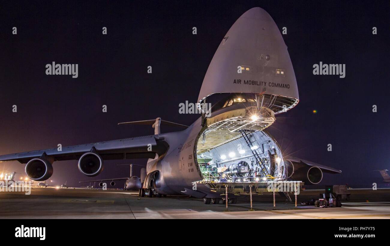 U.S. Airmen with the 60th Aerial Port Squadron load cargo onto a C-5M ...