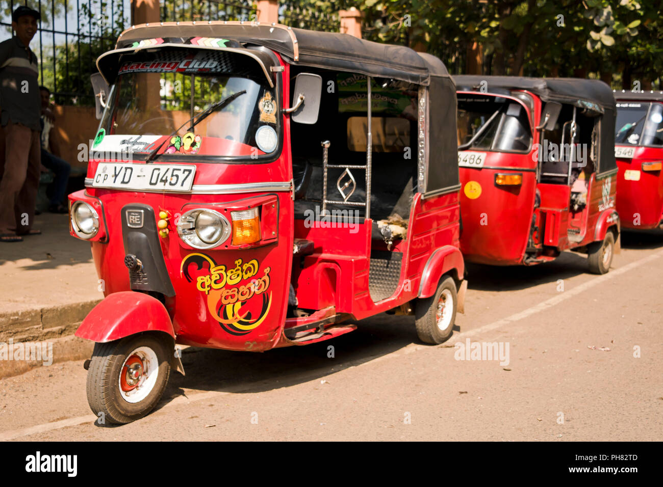 Horizontal view of a line of red rickshaws parked on the roadside Stock ...