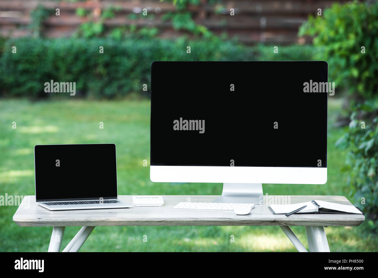 selective focus of textbook, laptop and computer with blank screens at ...