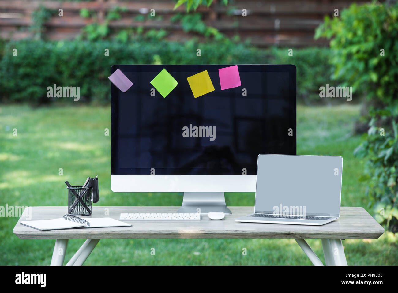 selective focus of textbook, laptop and computer with blank screens and ...