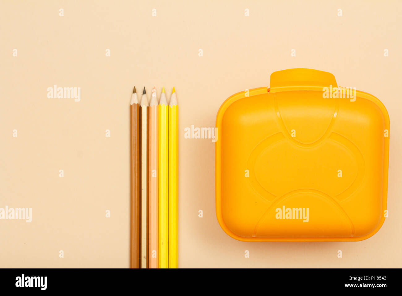 School supplies. Color pencils and lunch box on beige background. Top ...