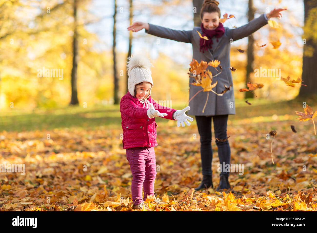 happy family playing with autumn leaves at park Stock Photo - Alamy