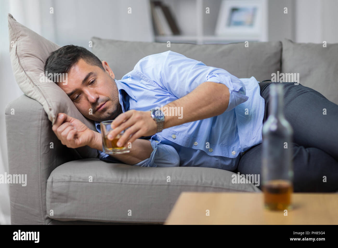 Alcoholic man sofa addiction hi-res stock photography and images - Alamy