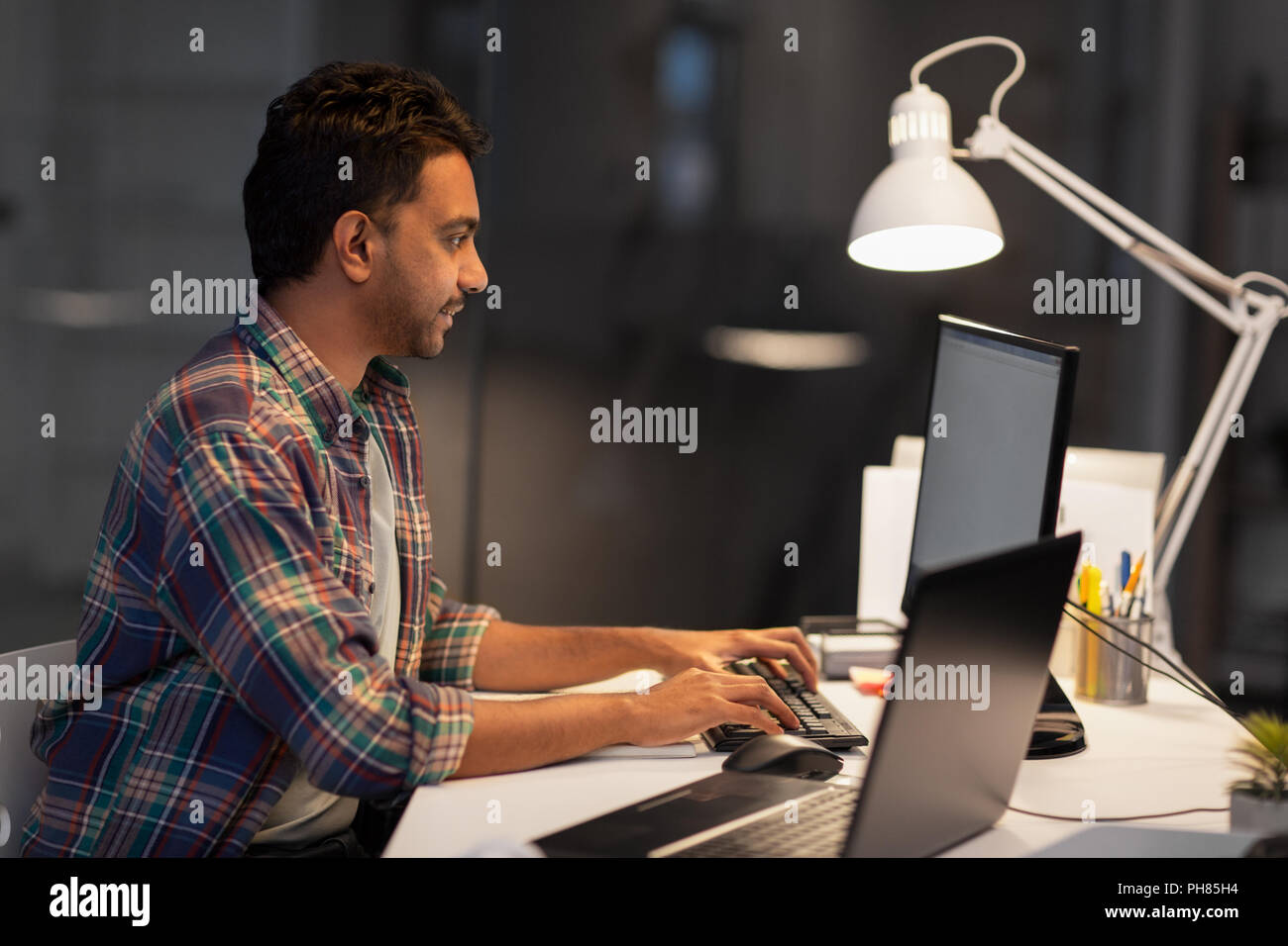creative man with computer working at night office Stock Photo - Alamy