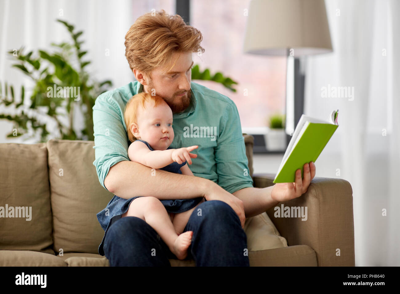 father reading book for baby daughter at home Stock Photo - Alamy