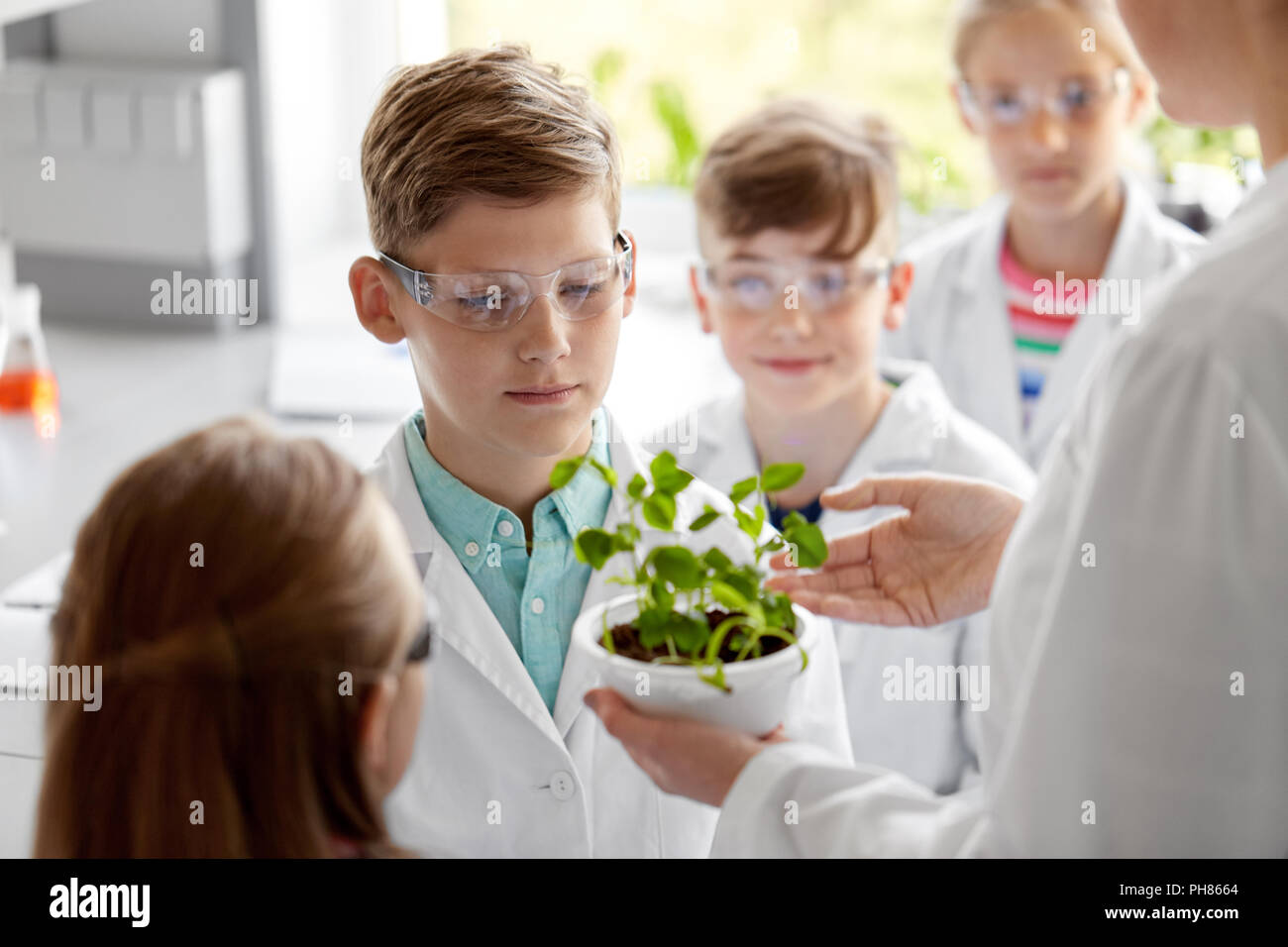 students and teacher with plant at biology class Stock Photo - Alamy