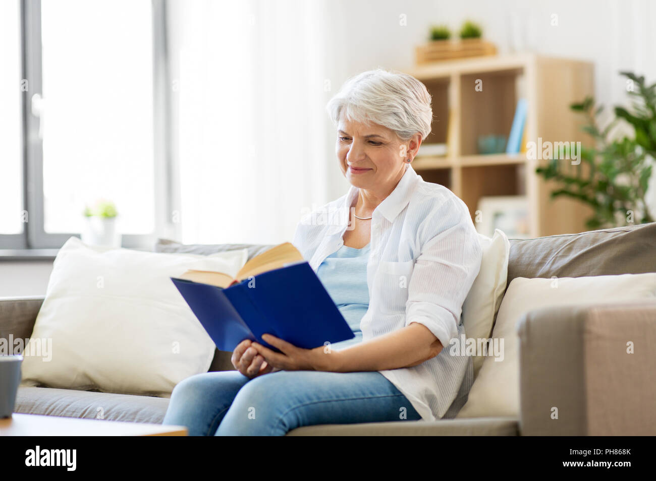happy smiling senior woman reading book at home Stock Photo - Alamy