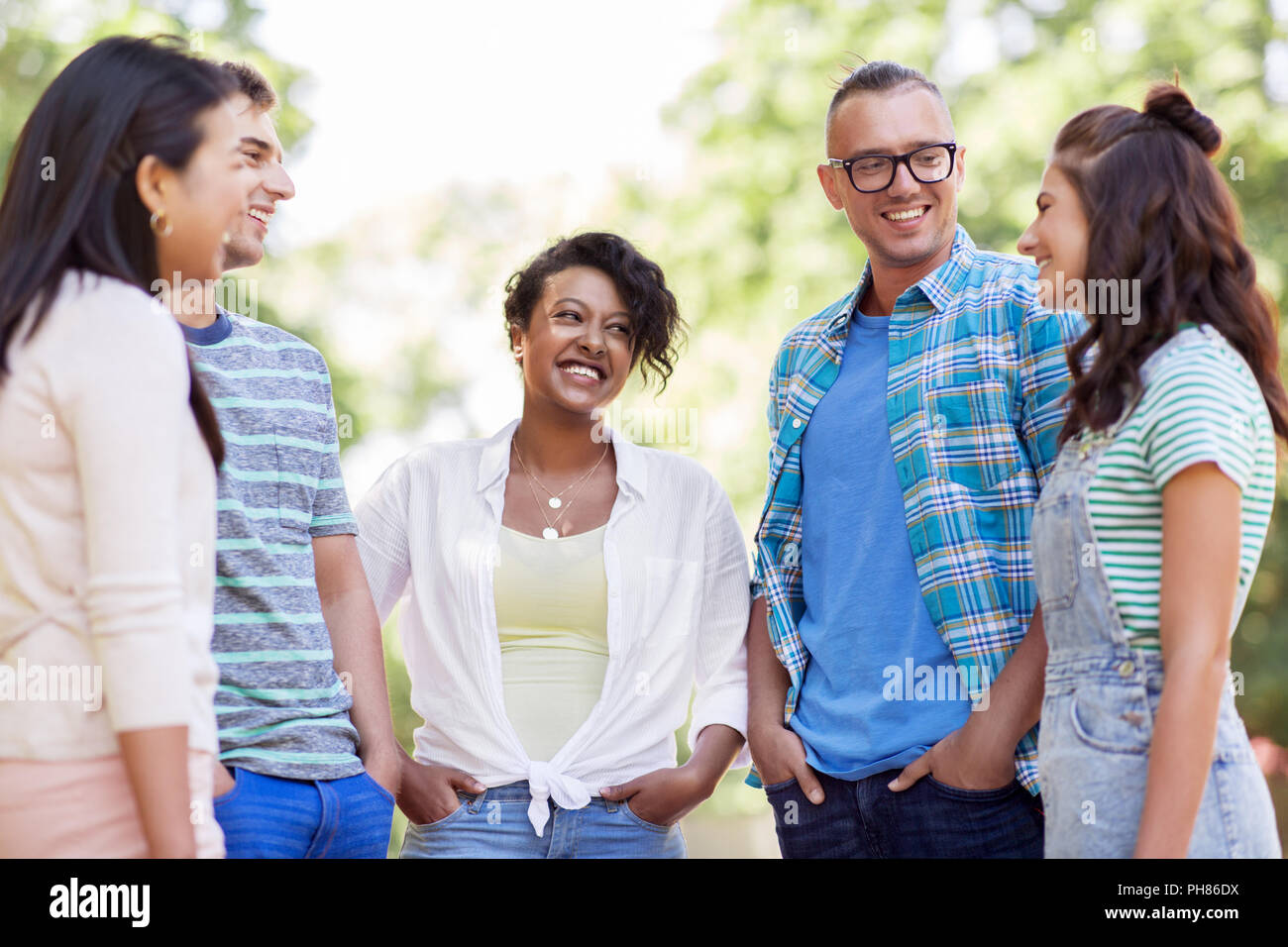 group of happy international friends in park Stock Photo - Alamy