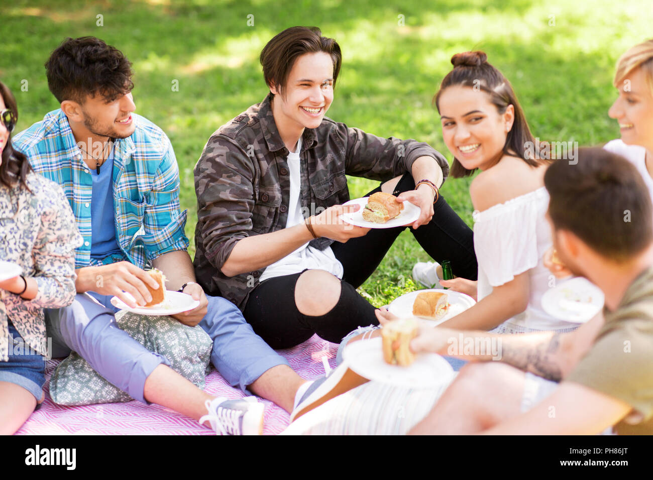 happy friends eating sandwiches at summer picnic Stock Photo - Alamy