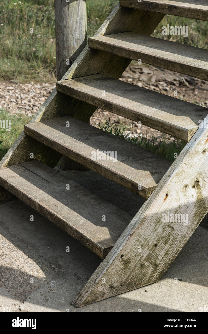 Homemade wooden access steps in close up with sun and shadows going up ...