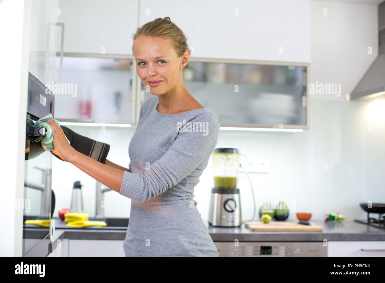 Pretty, young woman cooking in her modern kitchen Stock Photo - Alamy