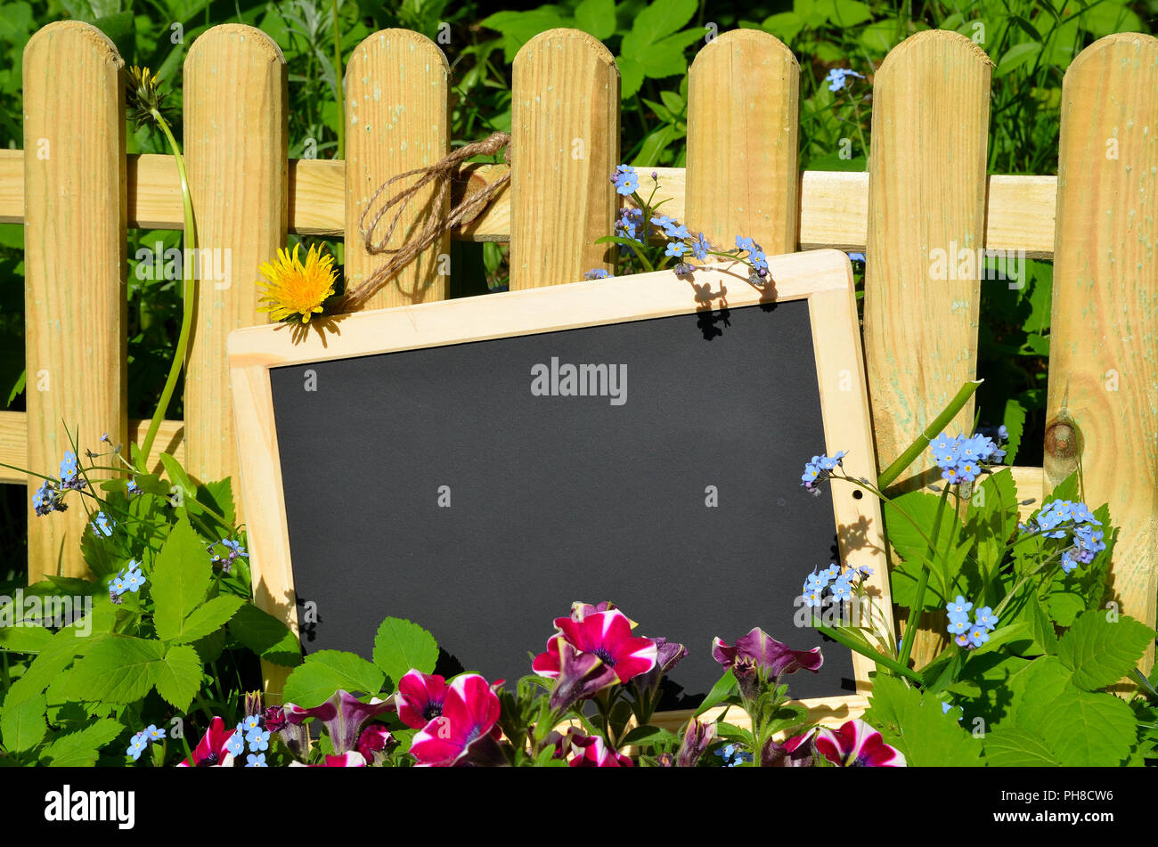 Wooden sign with flowers on fence Stock Photo - Alamy