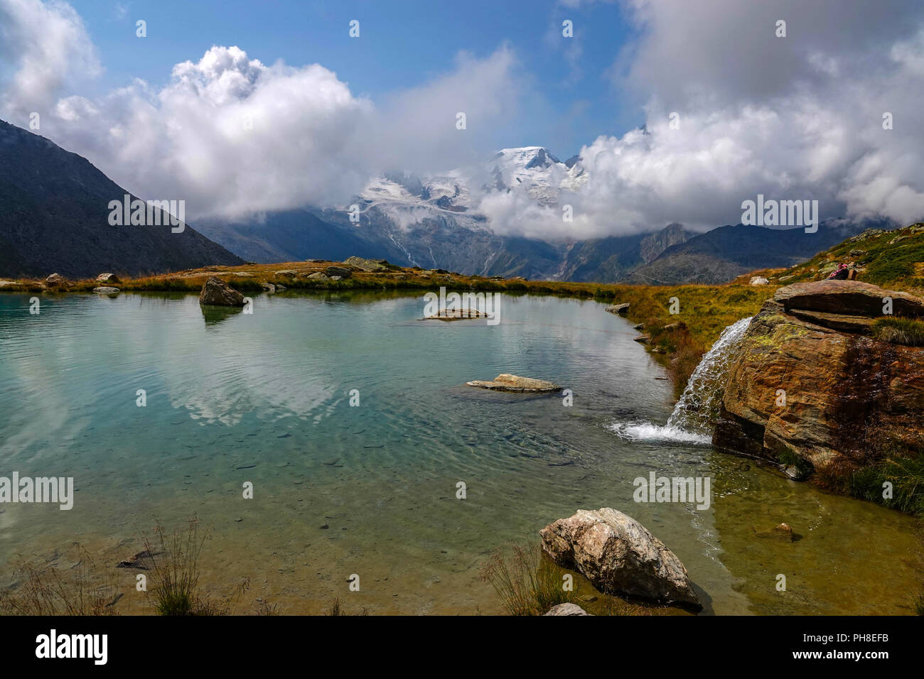 Small lake with waterfall, Summer at Hohe Saas cable-car above Saas ...