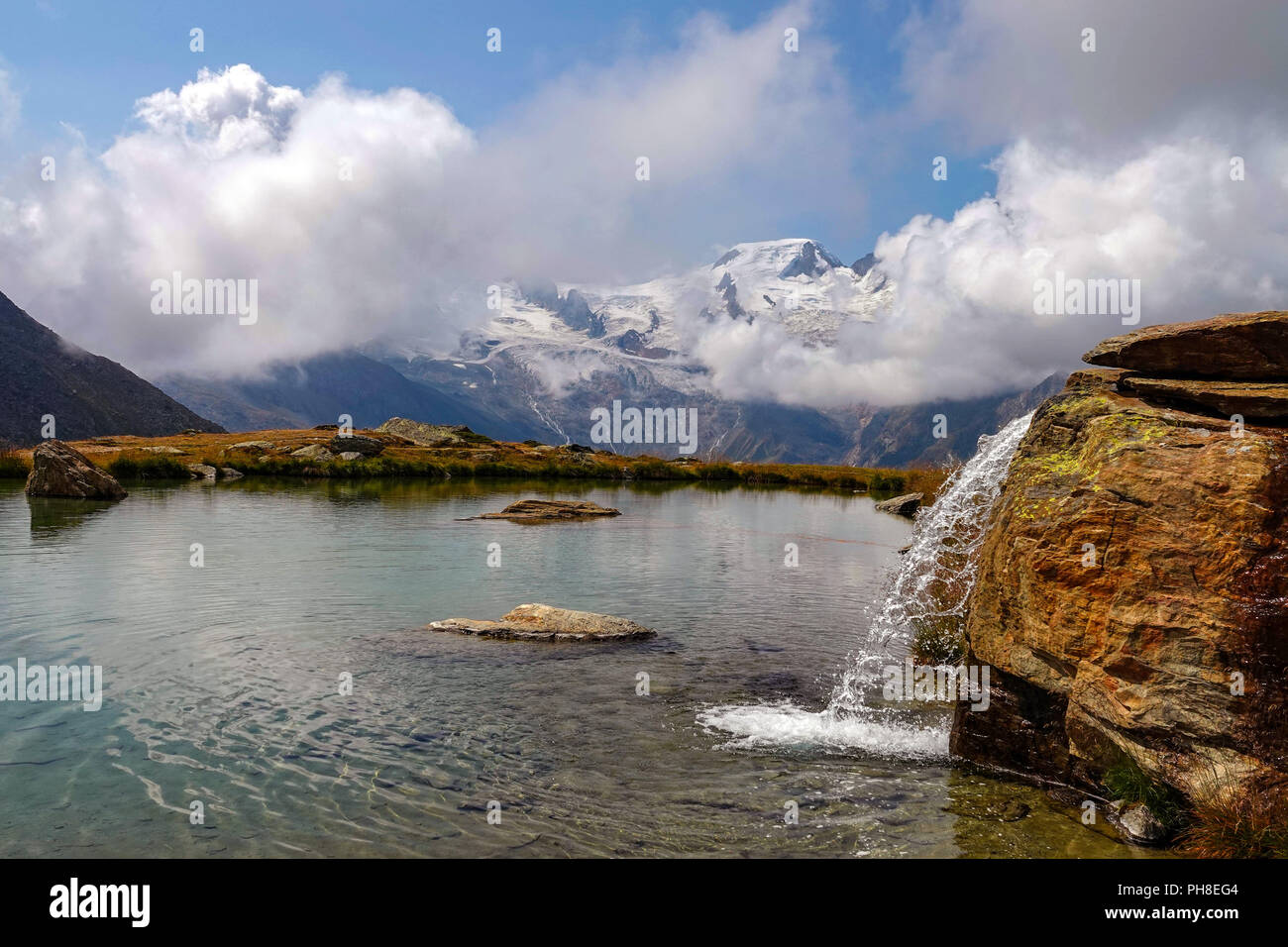 Small lake with waterfall, Summer at Hohe Saas cable-car above Saas ...