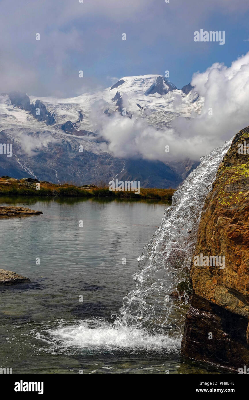 Small lake with waterfall, Summer at Hohe Saas cable-car above Saas ...